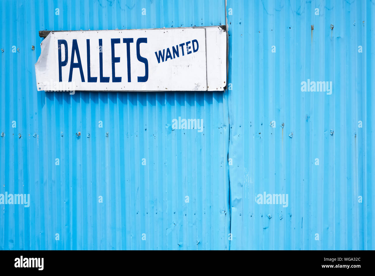 Pallets wanted sign for salvage recycle yard Stock Photo - Alamy