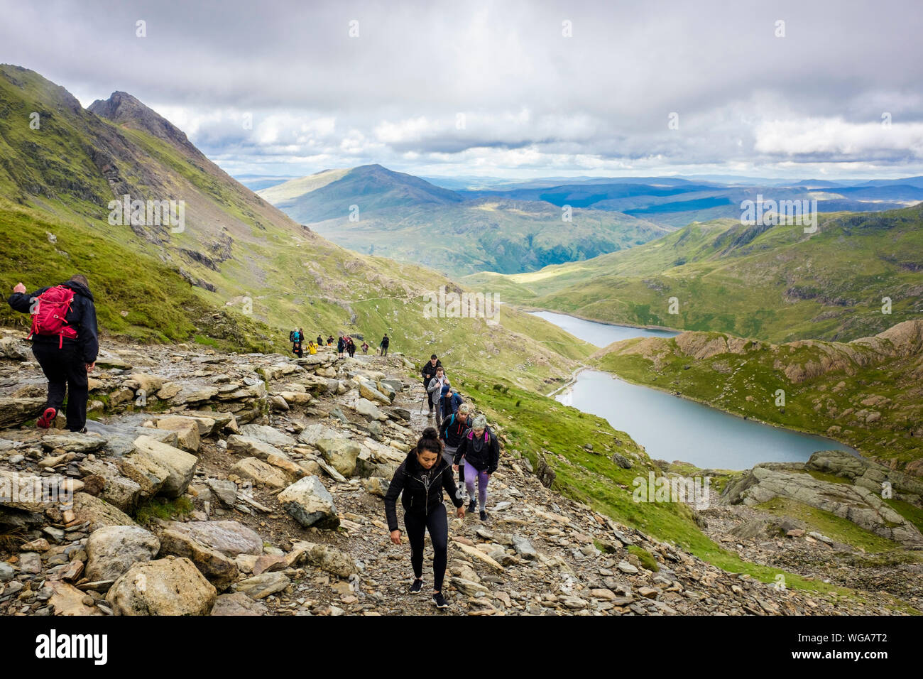 People walking up worn eroded Pyg Track busy route to Mt Snowdon above ...