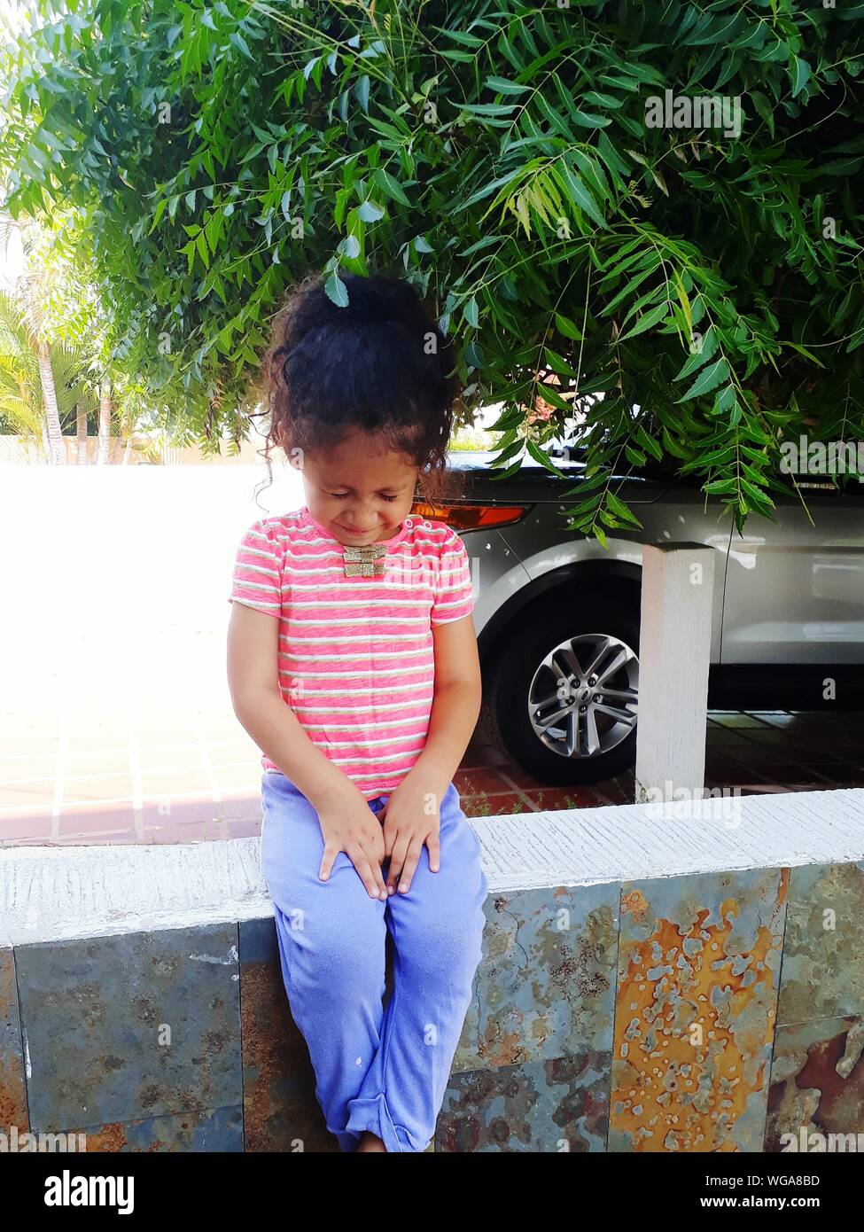 Girl child sitting wall hi-res stock photography and images - Alamy
