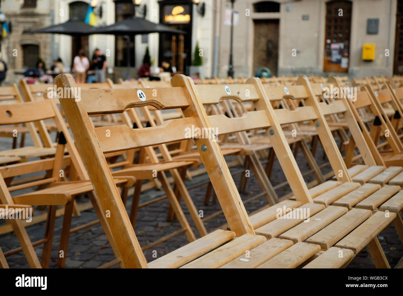 Set of empty folding wood chairs with numbers set on a public square at ...