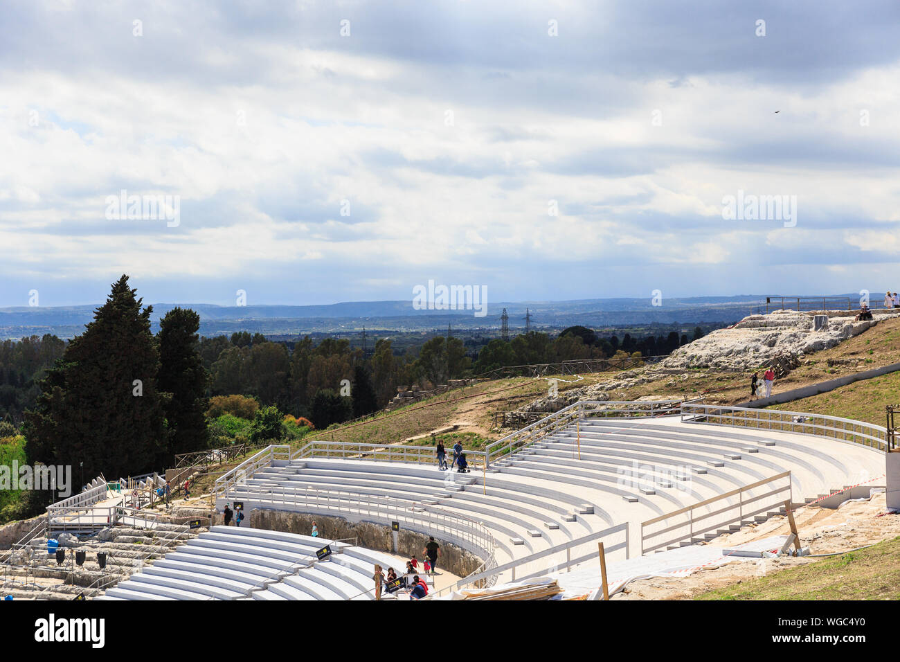 Tourists walks by Teatro Greco, Greek amphitheater steps in Siracusa ...