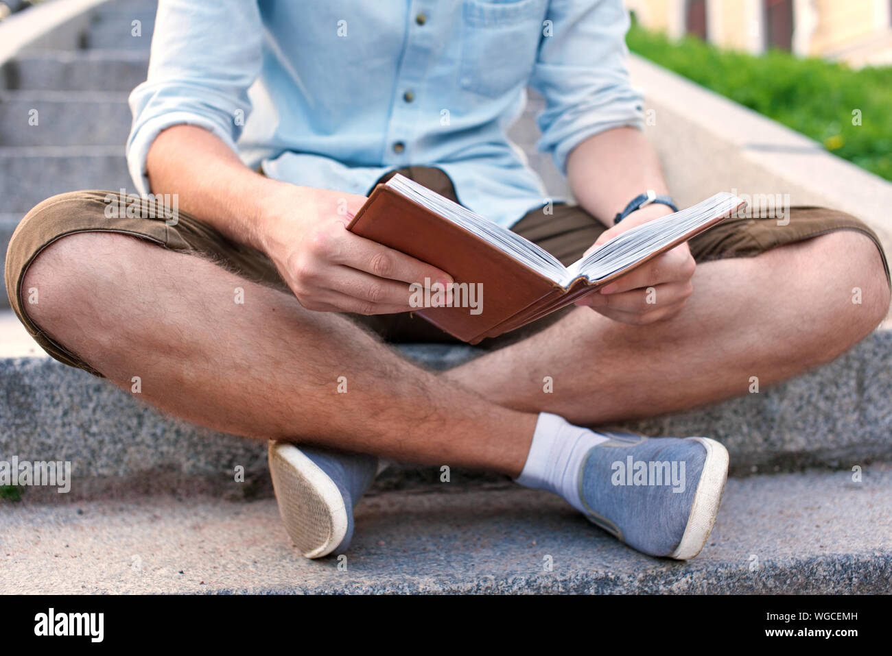 No face. Student with book sit on the stairs in campus Stock Photo - Alamy