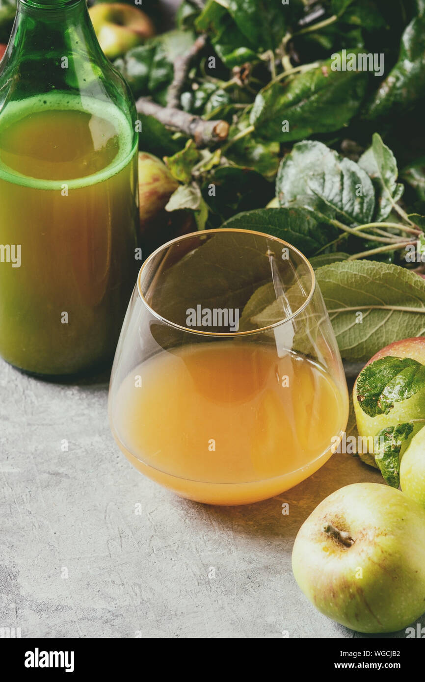 Bottles ang glass of apple cider low-alcohol drink with garden apples ...