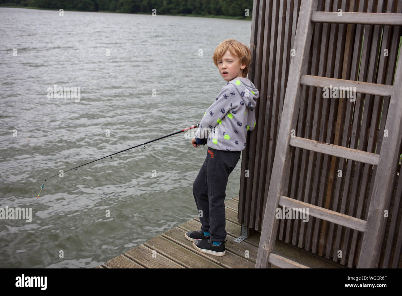 Boy on pier by lake hi-res stock photography and images - Alamy