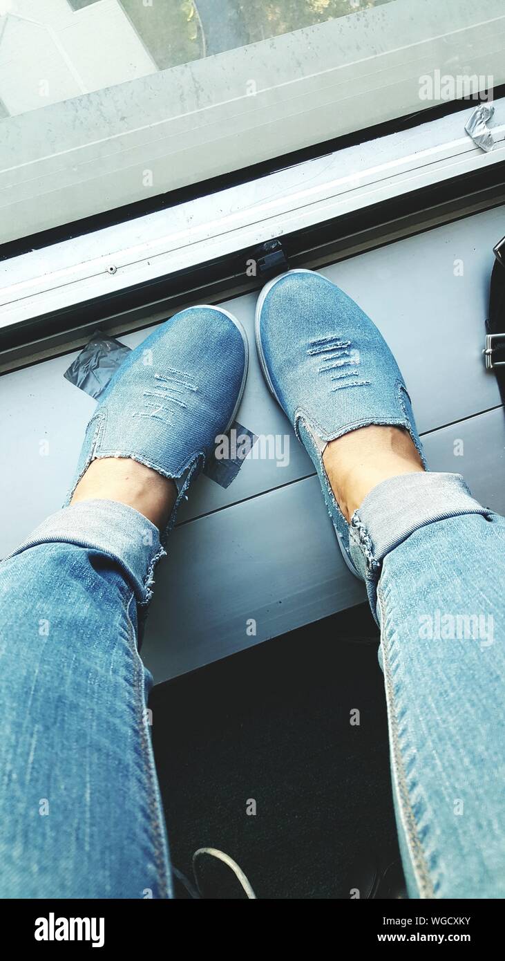 Low Section Of Person Standing On Window Sill Stock Photo - Alamy
