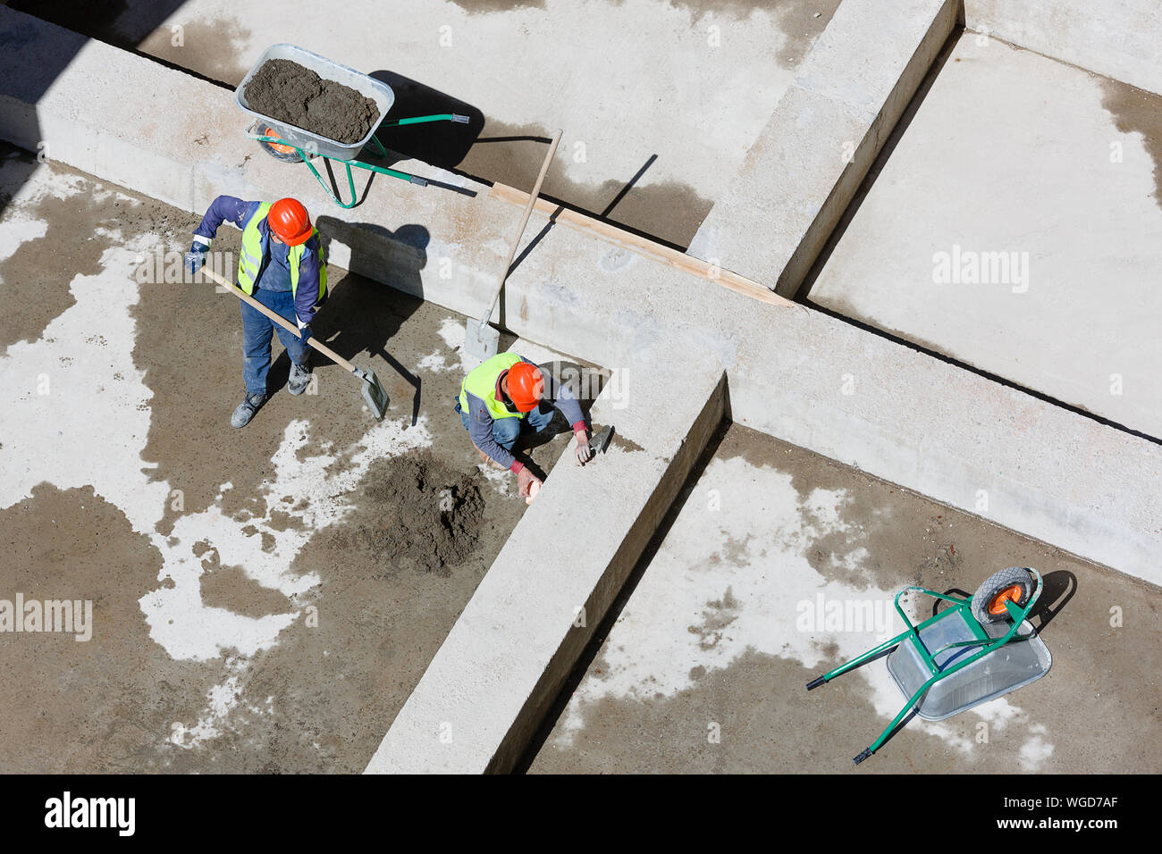 Uniformed workers clean sand on a construction site, top view Stock ...