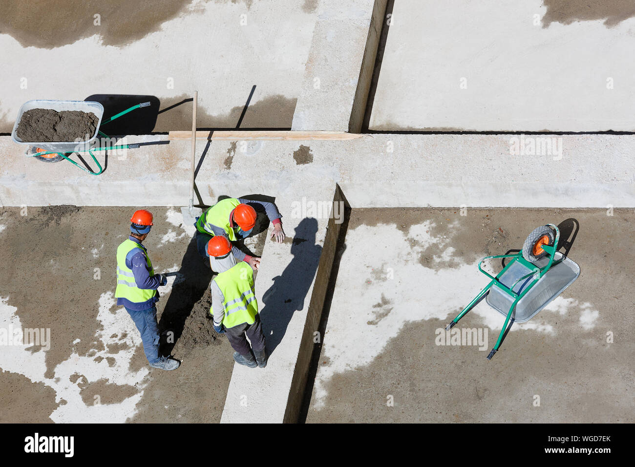 Uniformed workers clean sand on a construction site, top view Stock ...