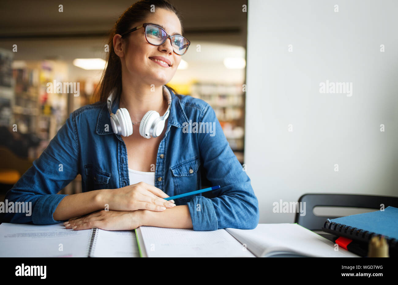 Beautiful happy student woman studying in library Stock Photo - Alamy