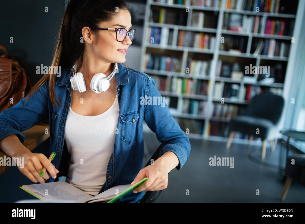 Beautiful happy student woman studying in library Stock Photo - Alamy