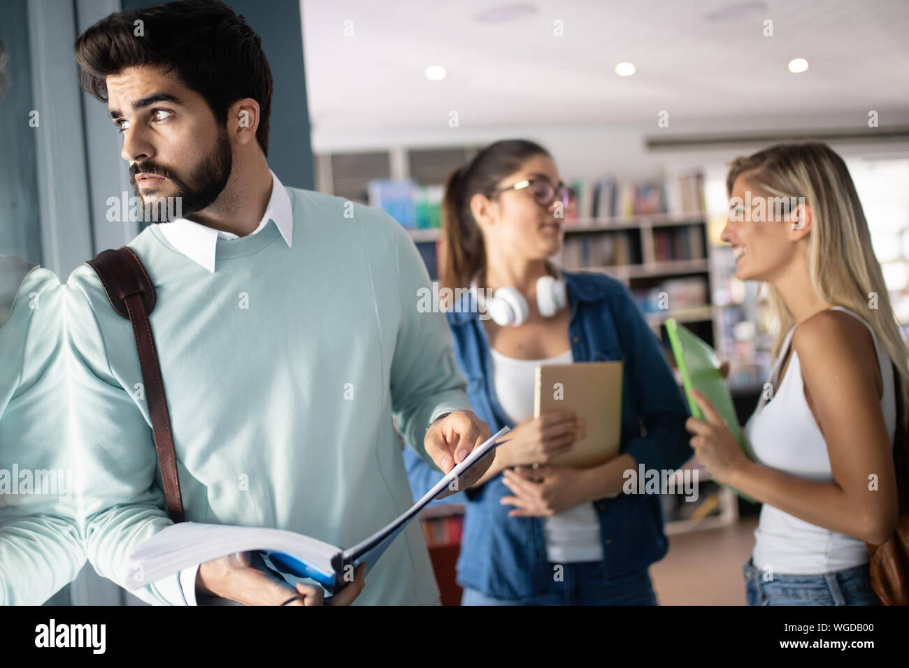 Happy university friends studying together in college Stock Photo - Alamy