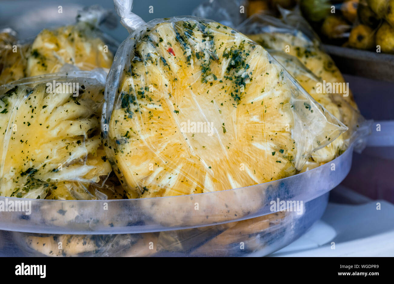 Slices of fresh pineapple Ananas comosus in plastic bags for sale Stock ...