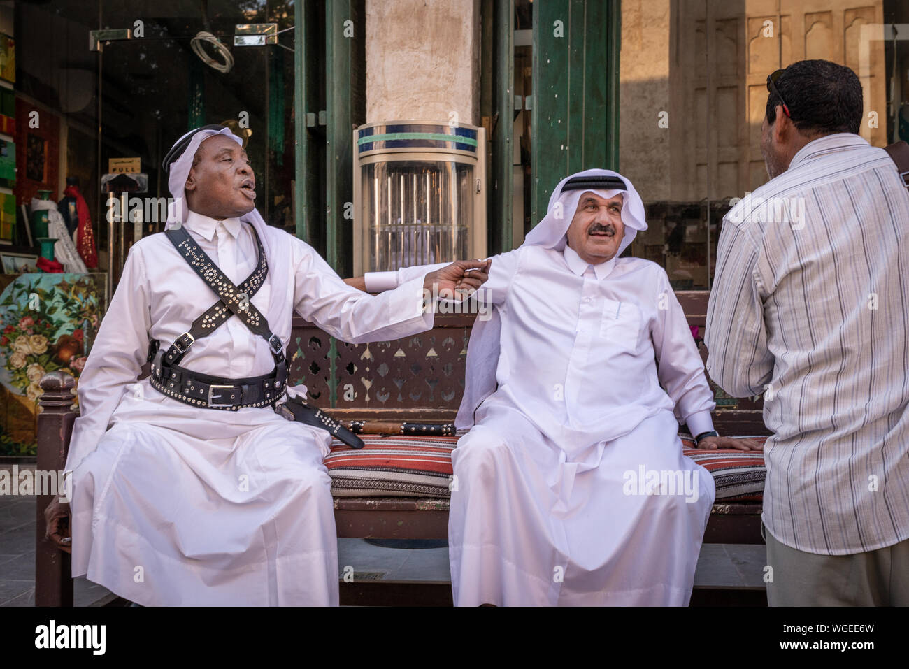 Doha, Qatar - 3 Dec 2016: Two men from Qatar are discussing on a bench ...