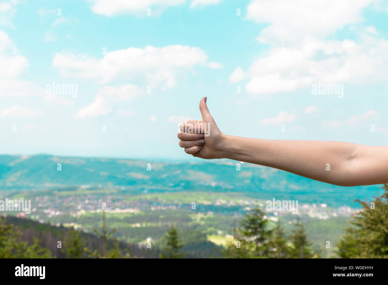 Hand shows thumbs up on the background of mountains Stock Photo - Alamy