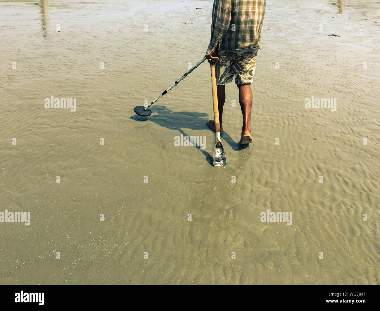 Low Section Of Man Holding Tools At Beach Stock Photo - Alamy