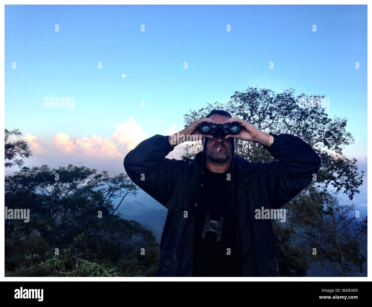 Man looking through binoculars sunset hi-res stock photography and ...