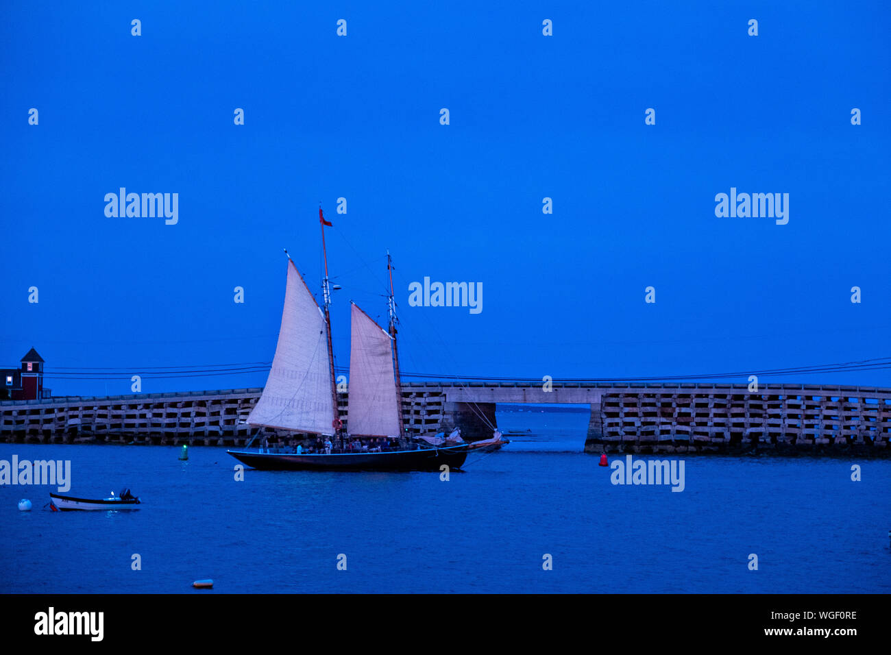 A Windjammer sailboat passes the Bailey Island Bridge, the only granite ...
