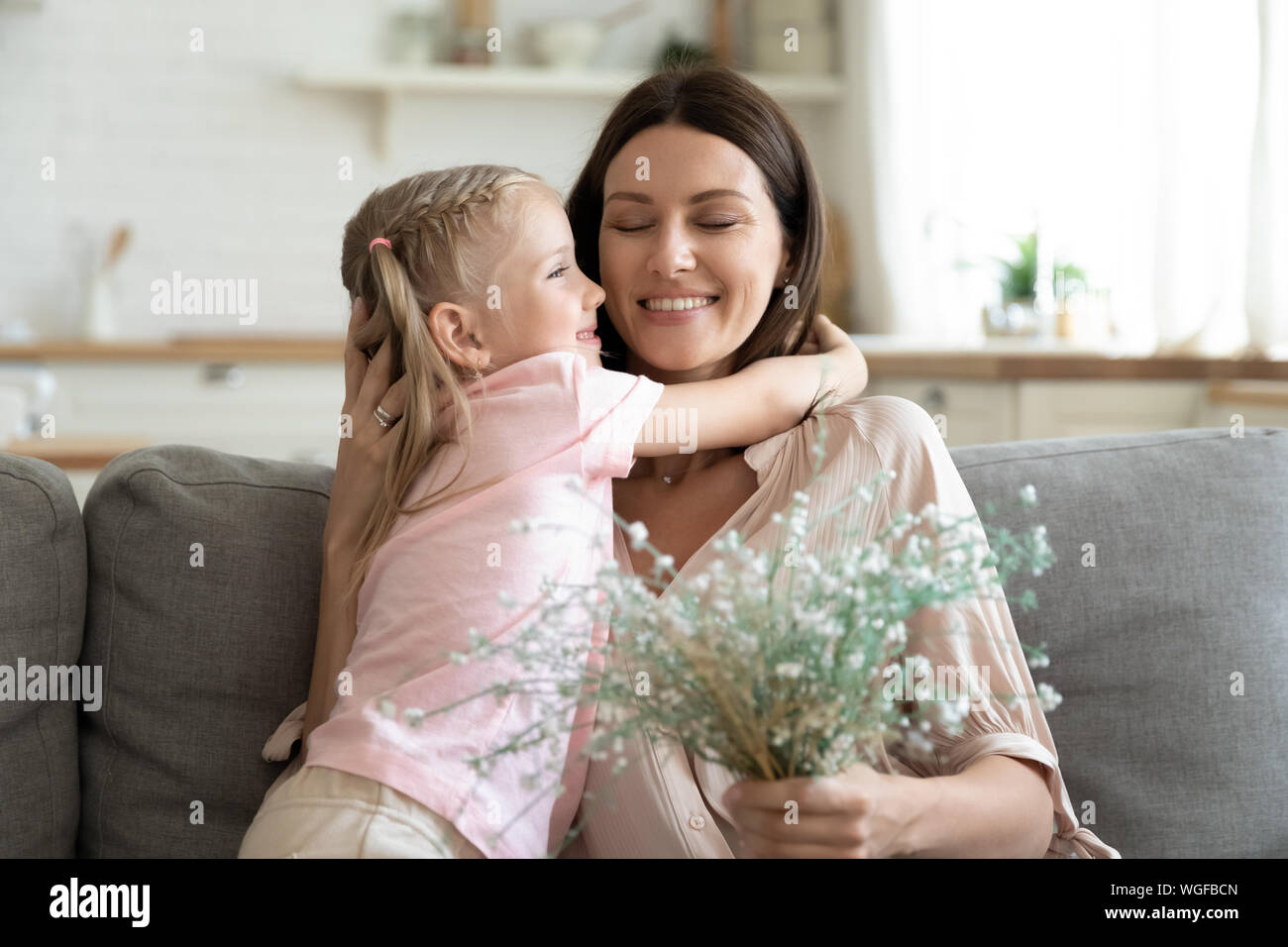 Daughter cuddle mother make pleasant surprise for her gave flowers ...