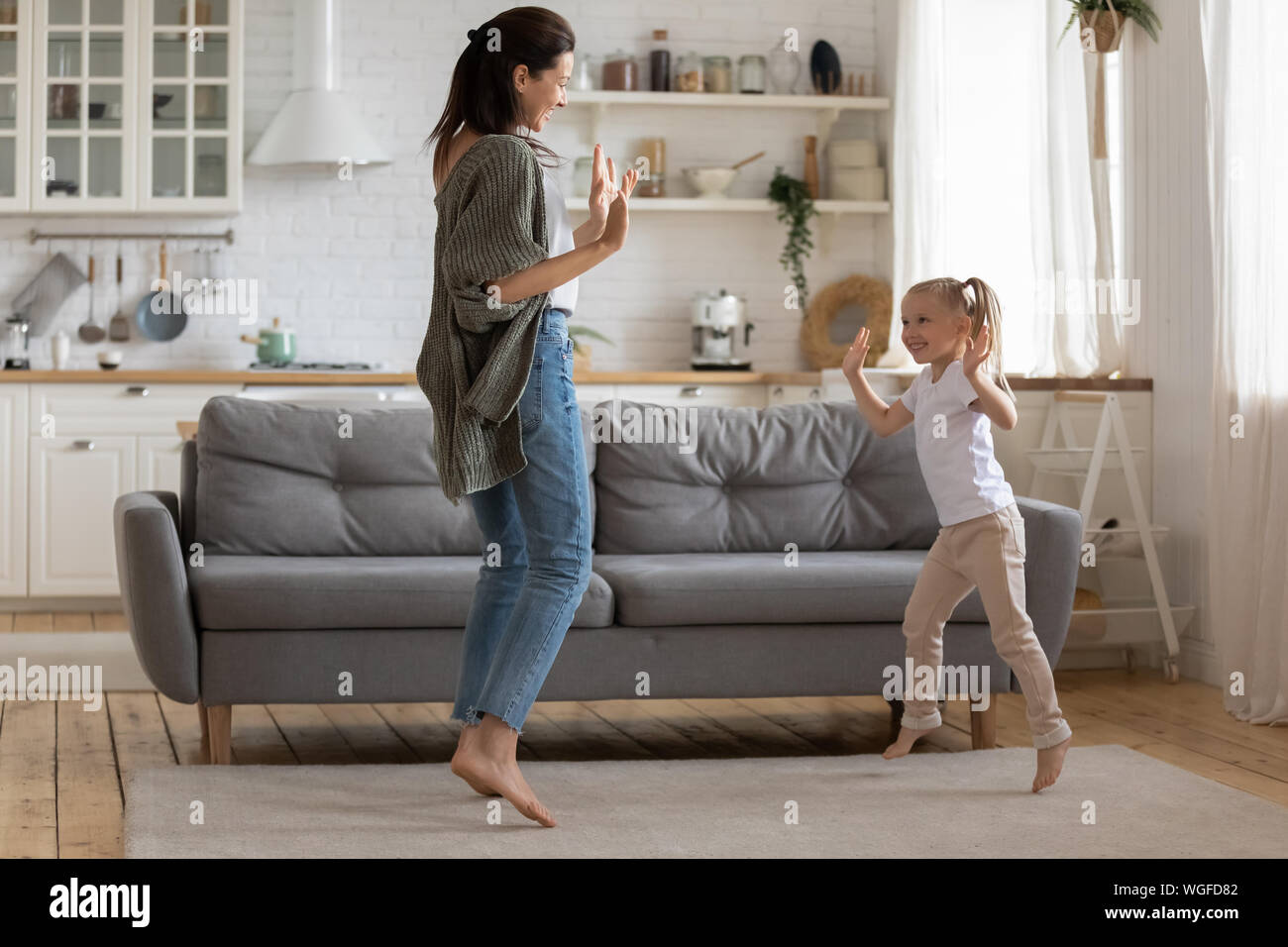 Full-length image mother dancing with preschool daughter at home Stock ...