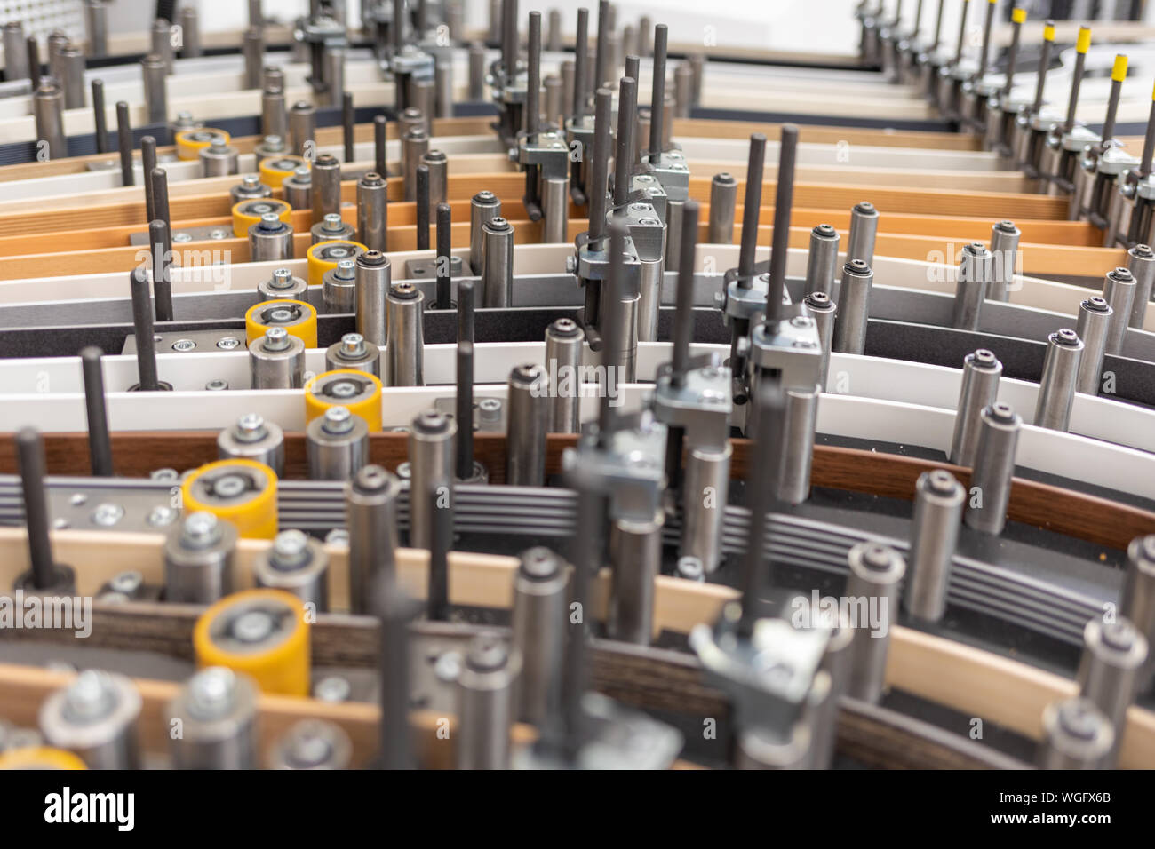 a close-up of a machine transporting plastic edges of different colours ...