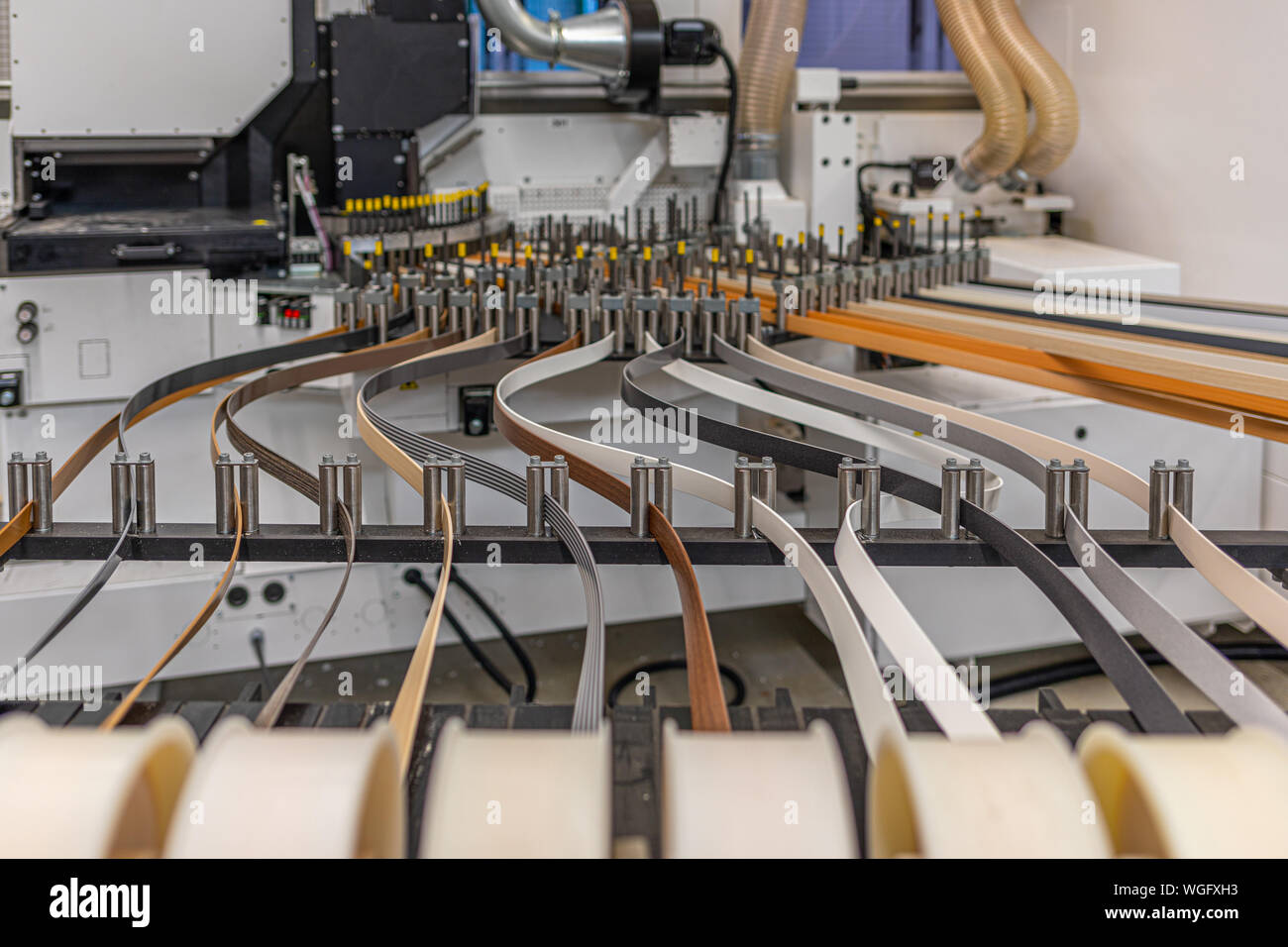 a close-up of a machine transporting plastic edges of different colours ...