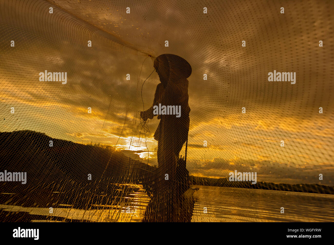 Man Throwing Fishing Net Into Water High Resolution Stock Photography ...