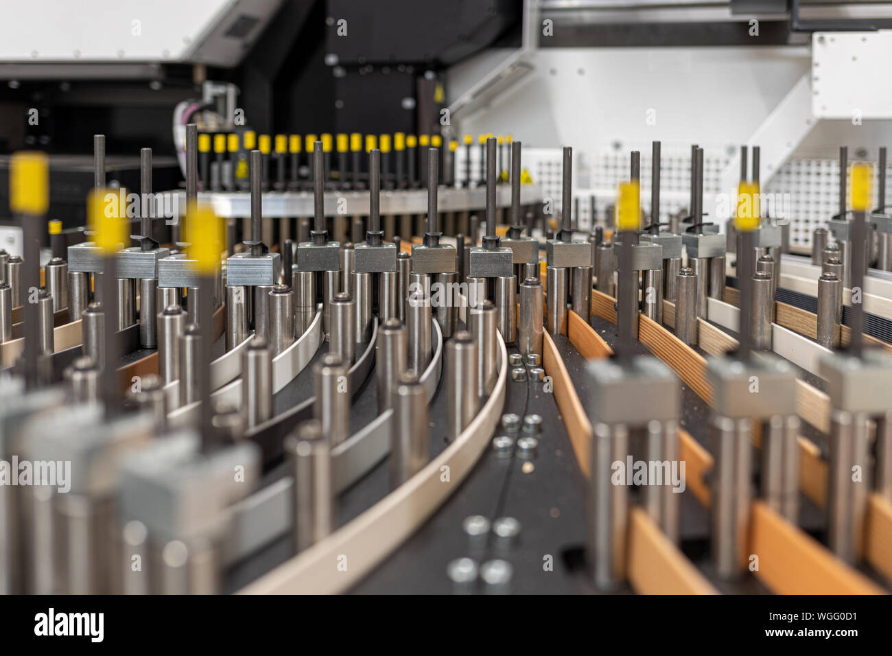 a close-up of a machine transporting plastic edges of different colours ...