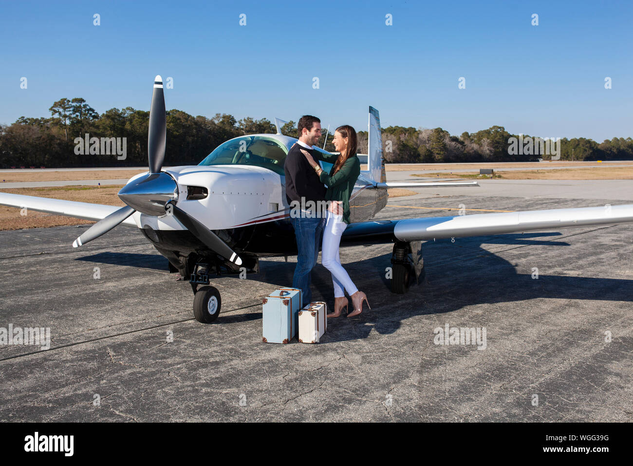 Couple in love with luggage and private plane Stock Photo - Alamy