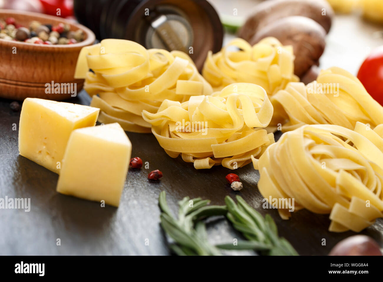 raw italian tagliatelli spaghetti on a black slate board with ...