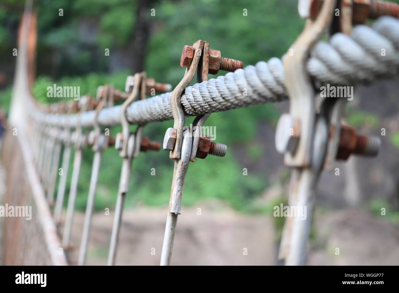 Nuts in the steel rope of a hanging bridge above water Stock Photo - Alamy