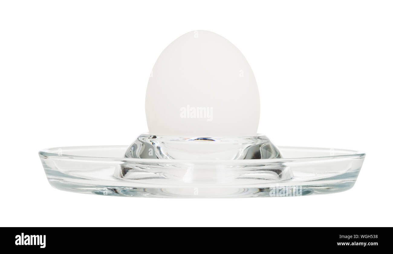 side view of boiled white egg in glass egg cup isolated on white ...