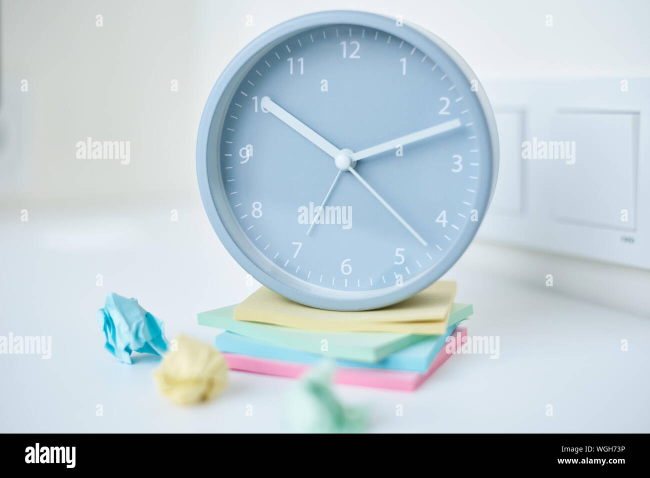 Gray round alarm clock and colorful sticky notes on white background ...