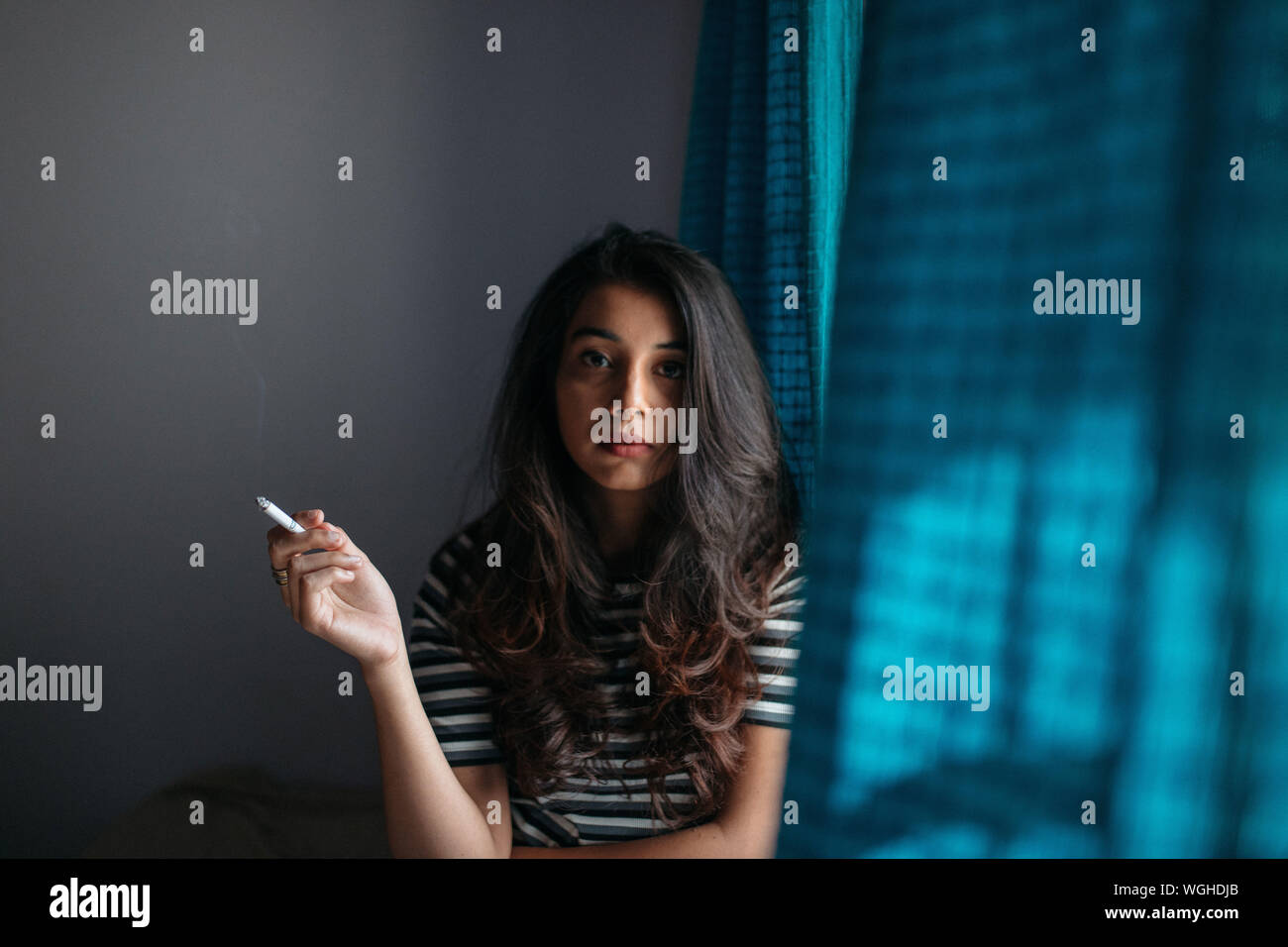 Woman smoking by window hi-res stock photography and images - Alamy