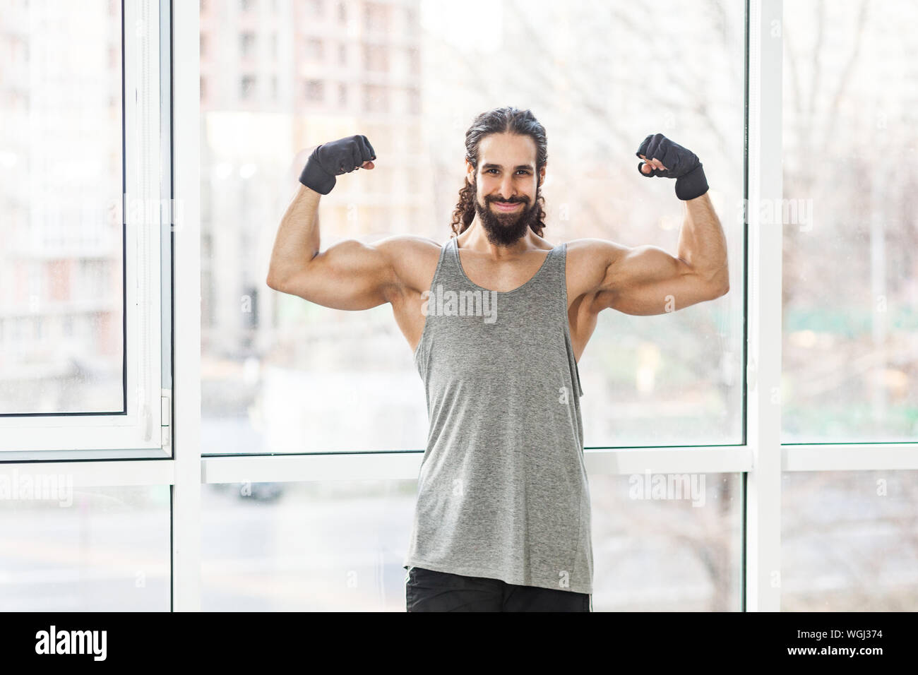 Portrait of happy satisfied sporty young adult muscular trainer man ...