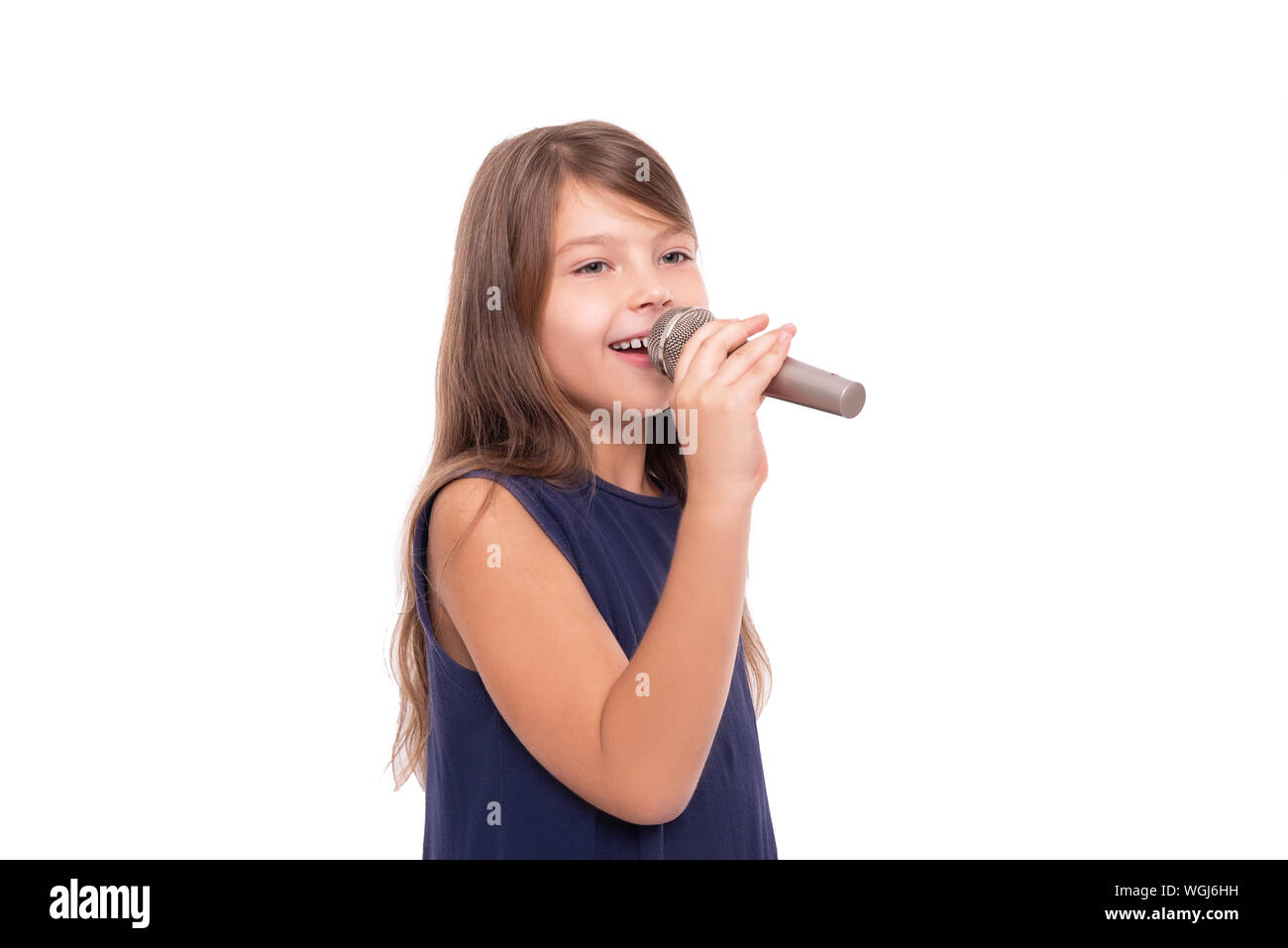 Little girl posing with a microphone for singing on white background ...