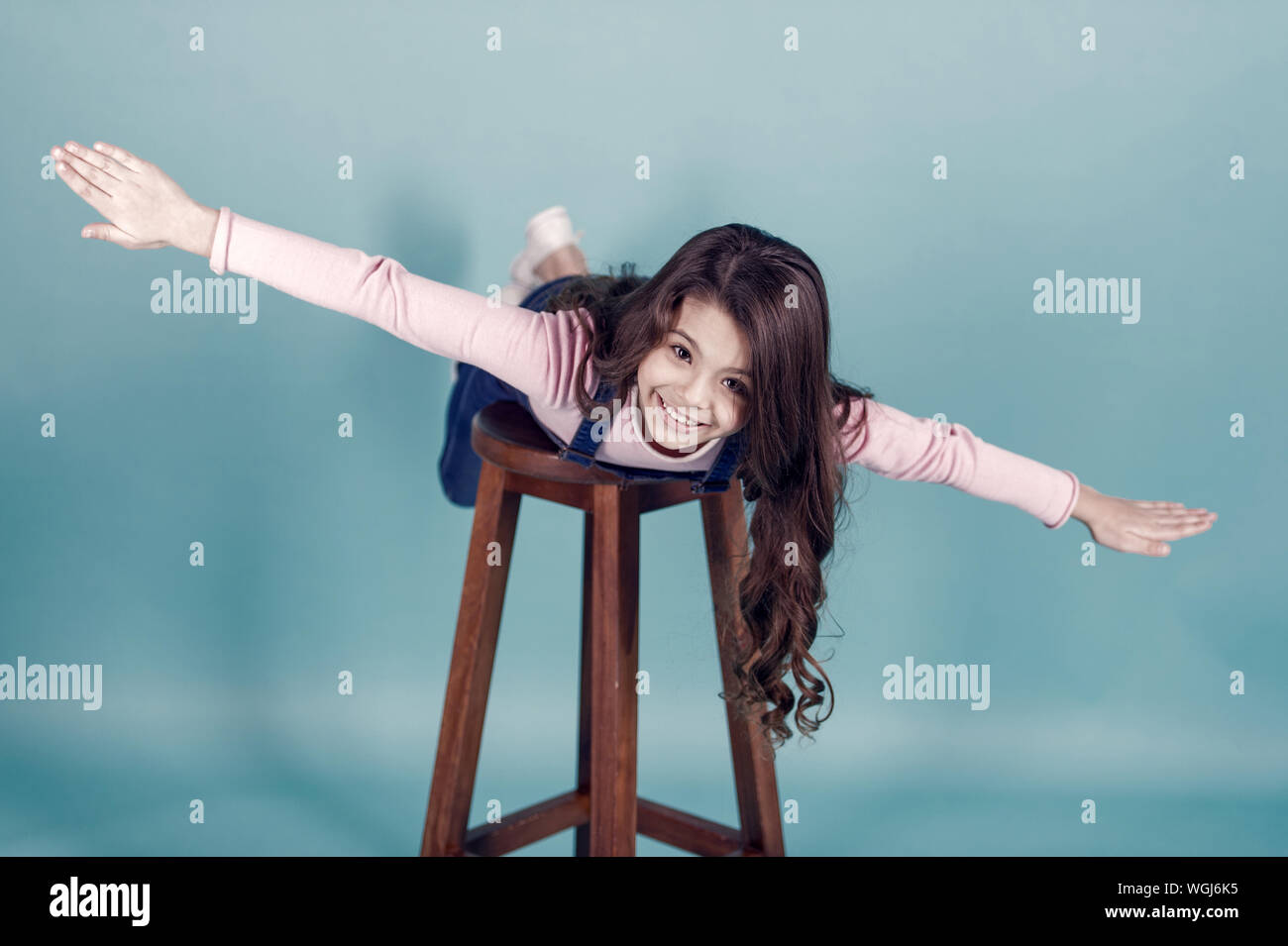 Follow me. Girl kid cheerful imitate plane flying. Kid play game fly as ...