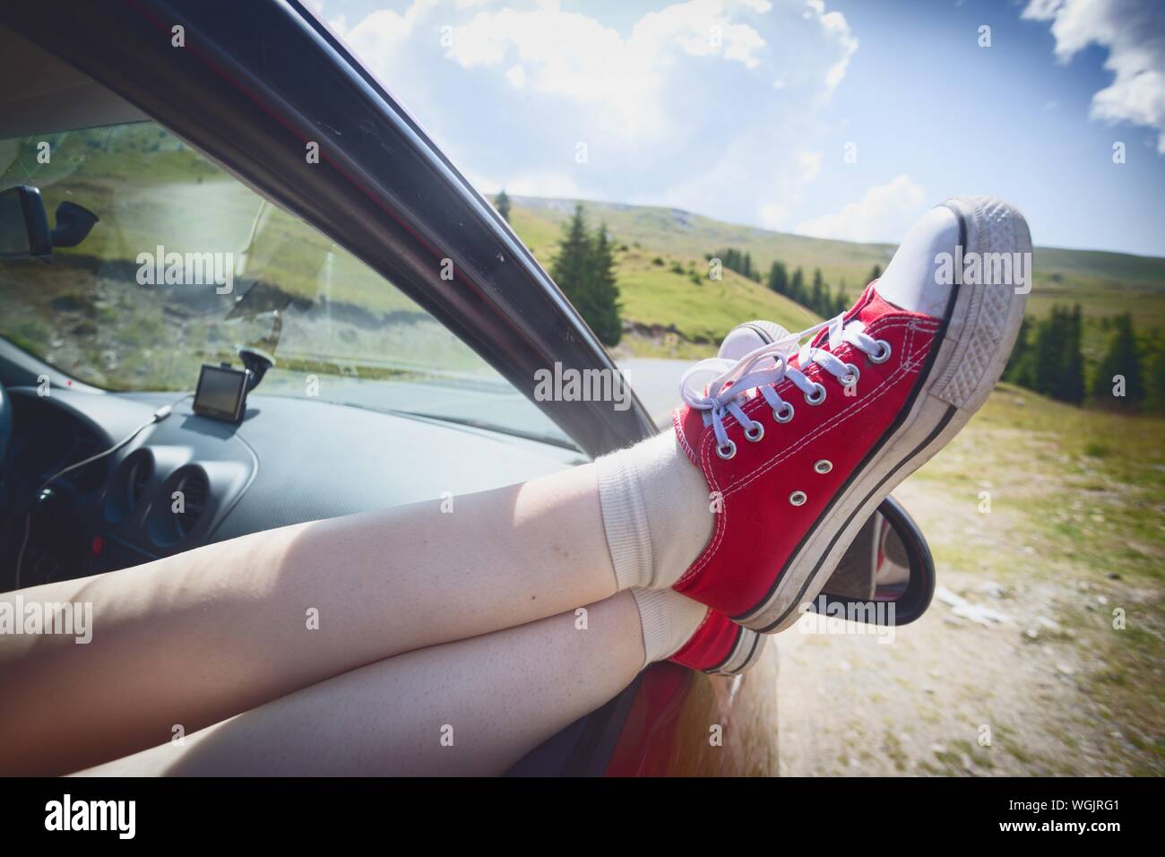 Girl legs in bright sneakers sticking out of the car Stock Photo - Alamy