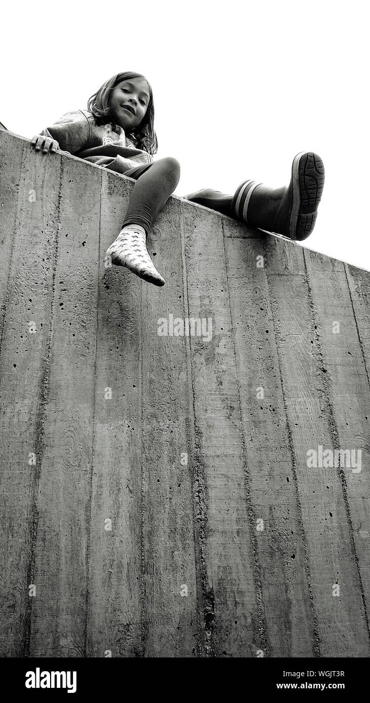 Girl sitting on wall low angle hi-res stock photography and images - Alamy