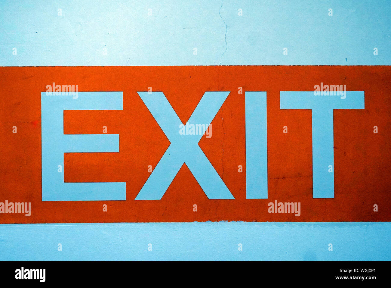 The word "EXIT" written on a white wall with orange surrounding Stock ...