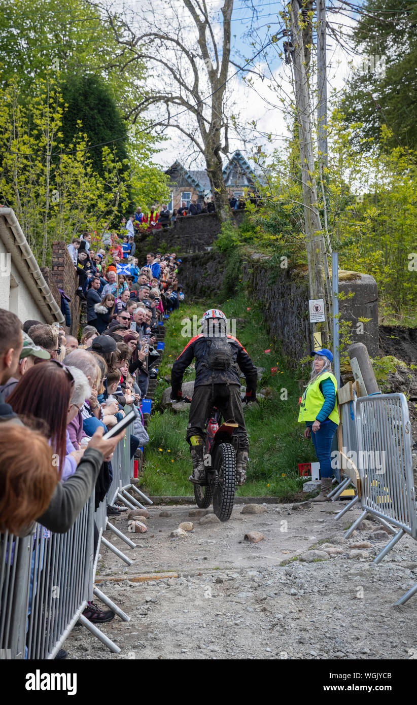Scottish Six Day Trial motorcycle rider goes up a very steep and rocky ...
