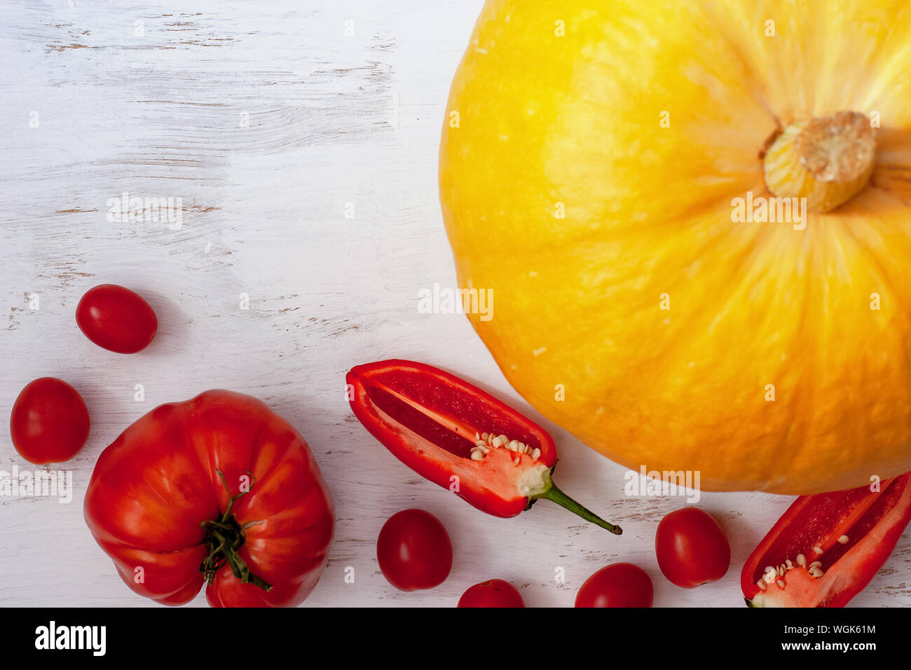 Flat view. Big pumpkin, big red tomato, sliced red pepper and small ...
