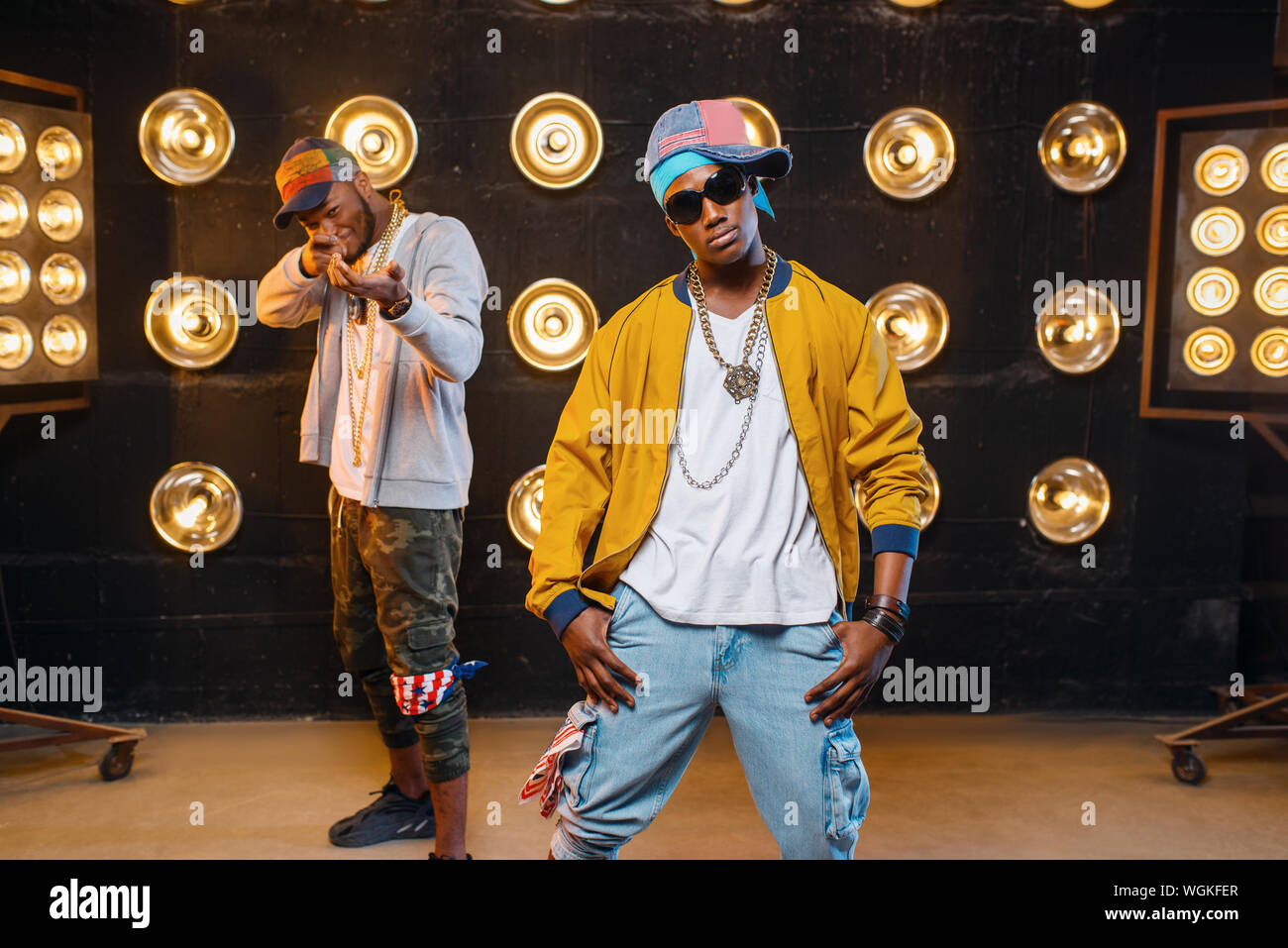 Two black rappers in caps on stage with spotlights Stock Photo - Alamy