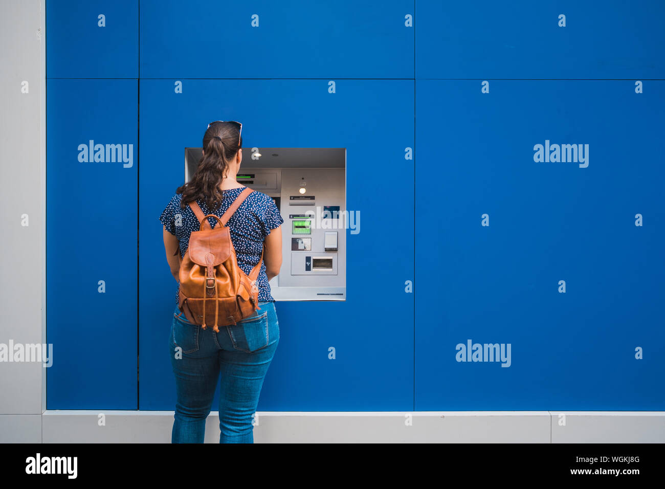 Young beautiful woman inserting credit card and withdrawing money from ...