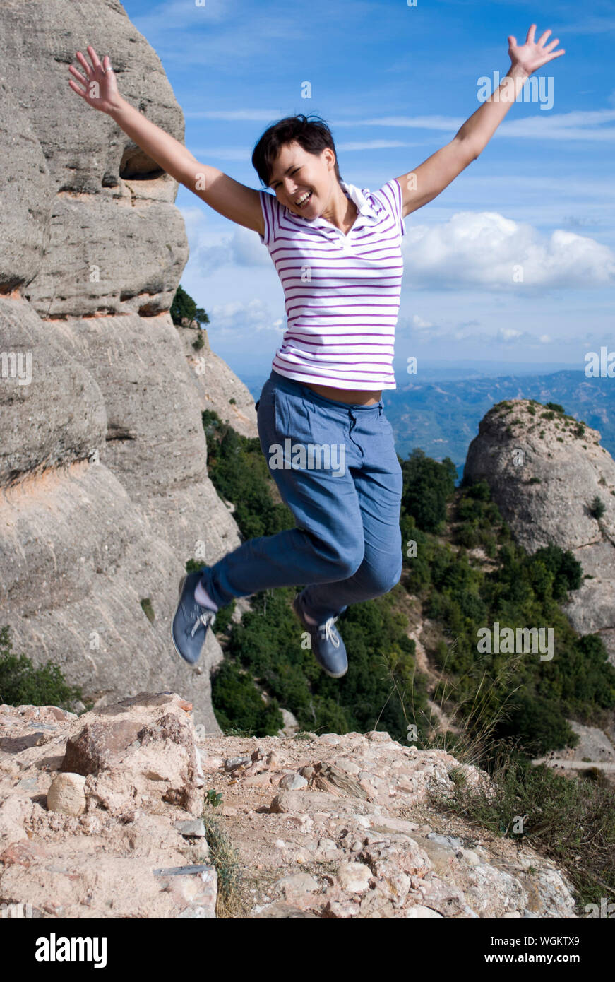 Woman jumping rock formation hi-res stock photography and images - Alamy