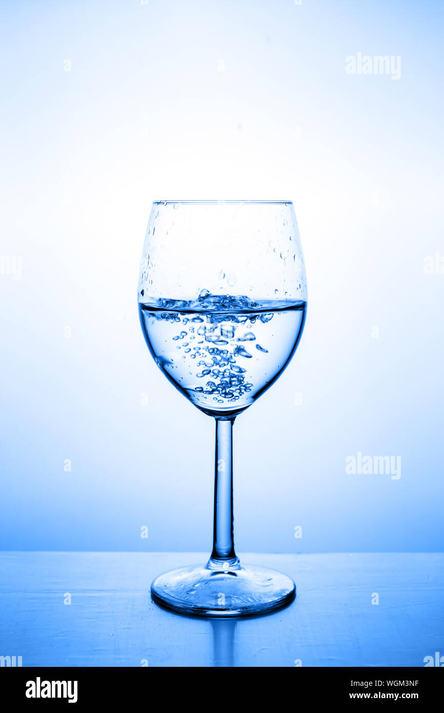 Glass with water up and splash Stock Photo - Alamy