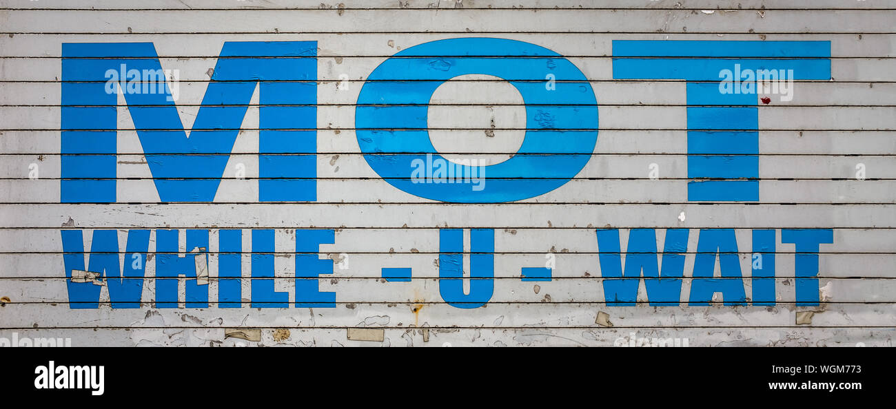 A Grungy Old MOT While You Wait Sign In The UK Stock Photo - Alamy