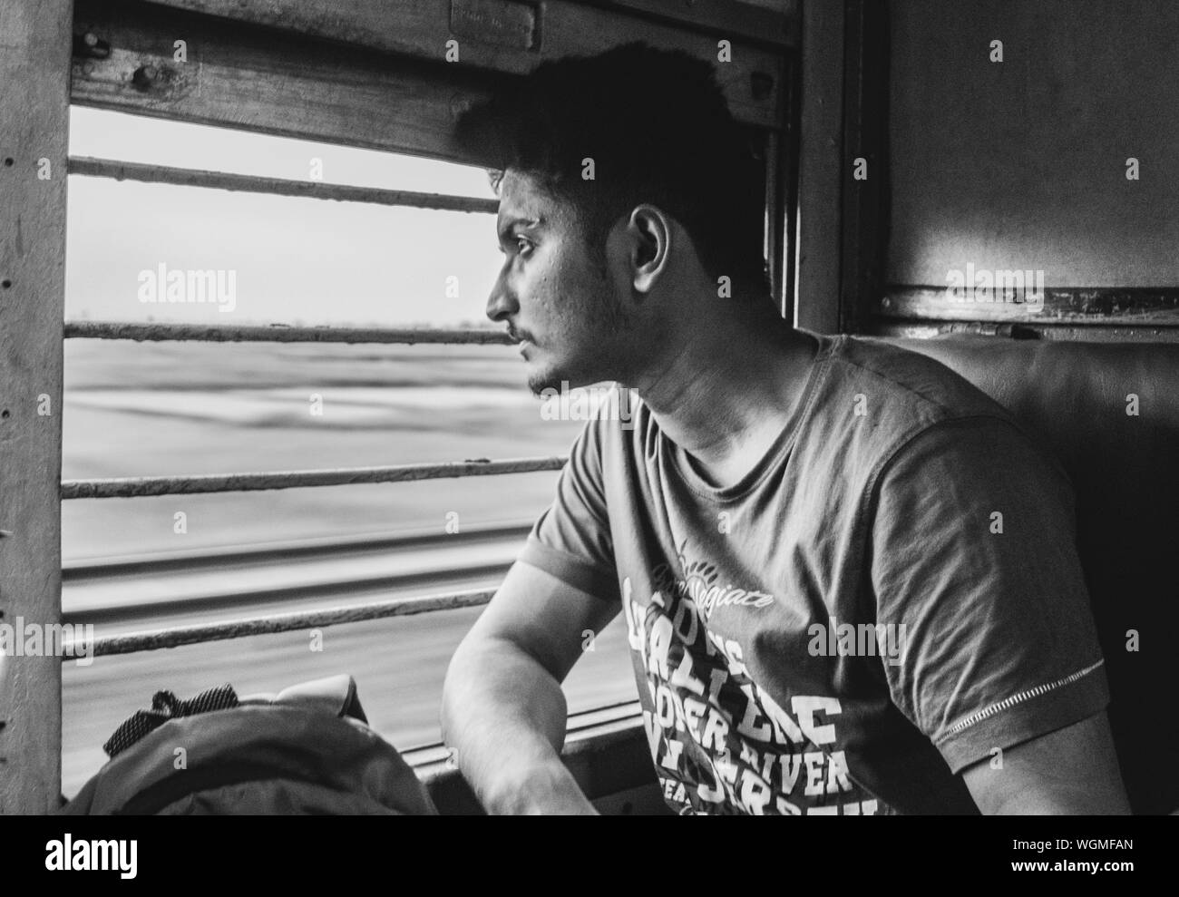 Man looking through train window Black and White Stock Photos & Images ...