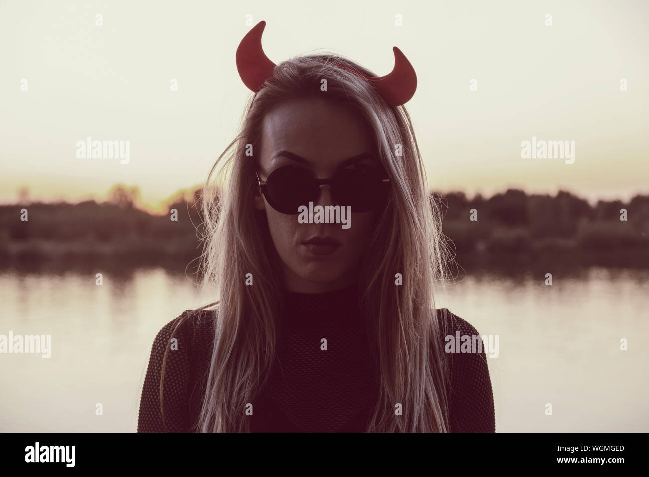 Deadlly serious female wearing sunglasses and Devils horns posing in ...