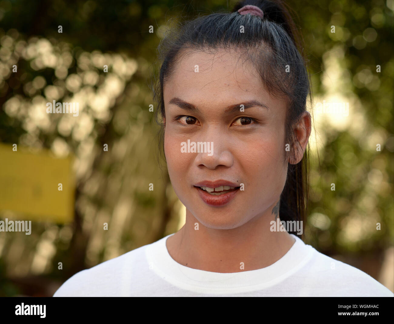 Young Thai genderqueer (kathoey) with sensual lips and a long ponytail ...