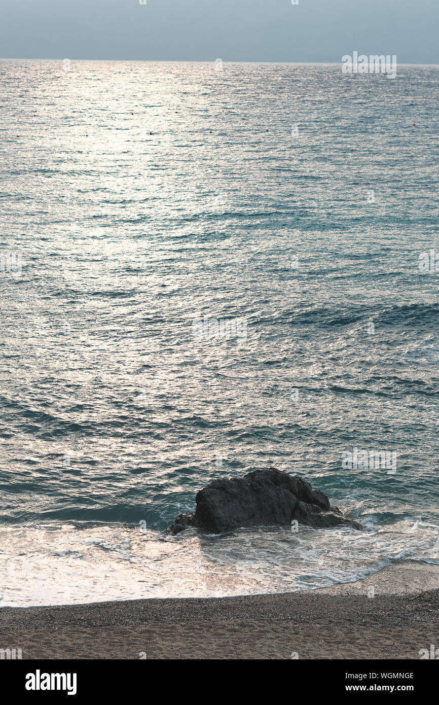 single rock in the sea during morning dawn Stock Photo - Alamy