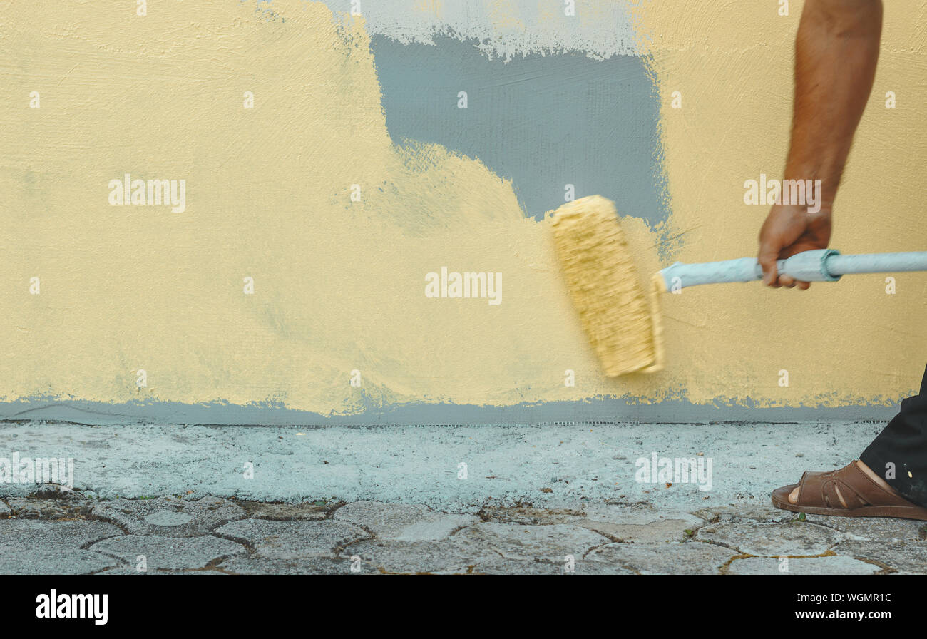 hand with paint roller painting an outside wall Stock Photo - Alamy
